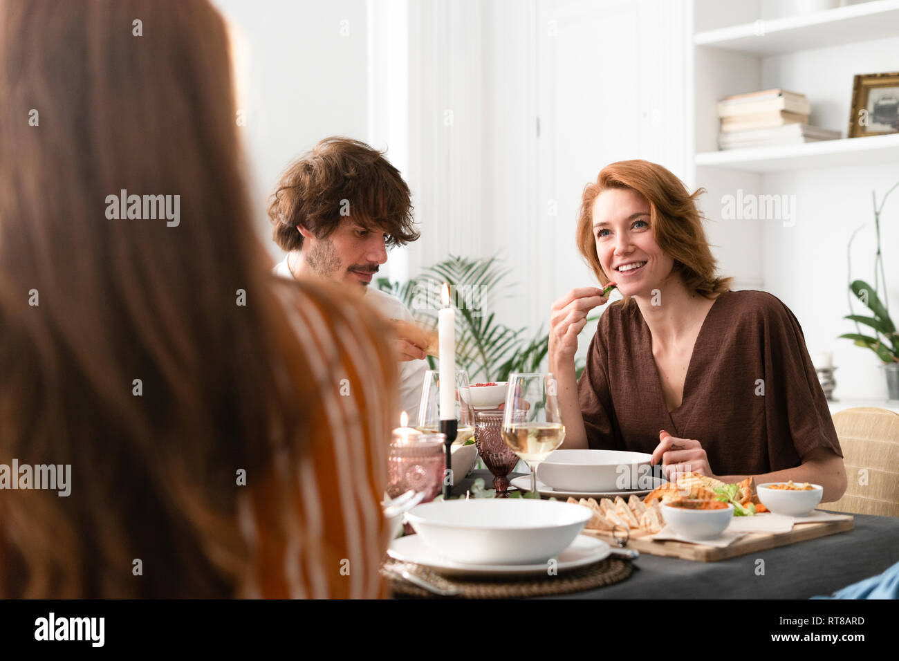 Friends having fun at a dinner party, enjoying eating together Stock ...