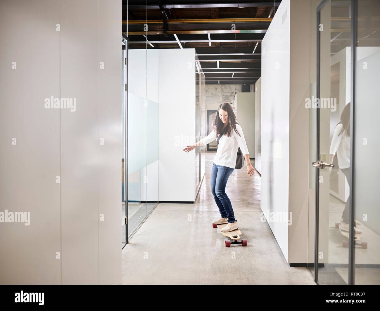 Woman riding longboard office floor hi-res stock photography and images ...