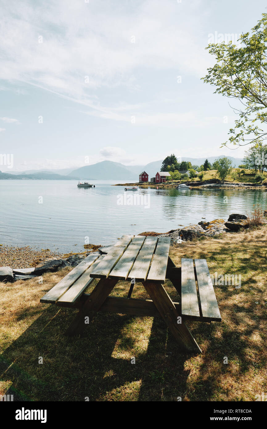 A outdoor picnic table and the small island of Omaholmen on a beautiful summers day in ...