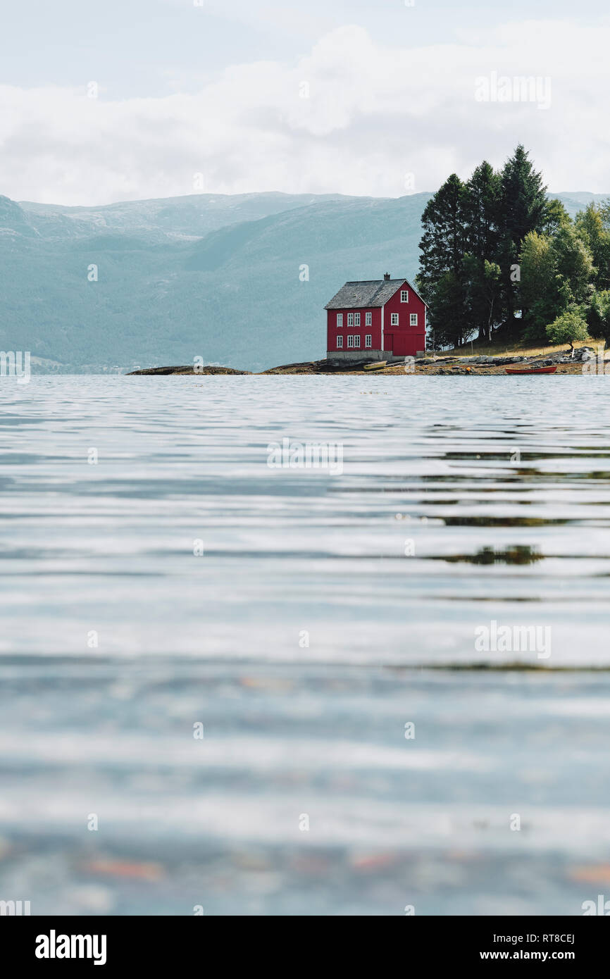 The tradtional red house on the small island of Omaholmen in Hardangerfjord Hordaland, Norway ...