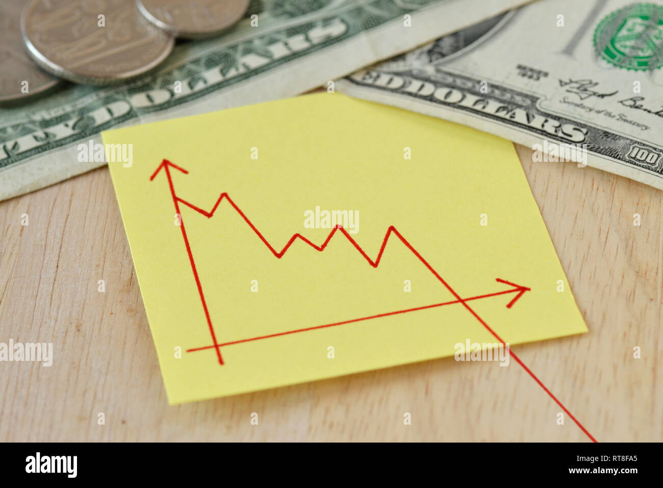 Graphic with descending line on paper note, dollar coins and banknotes ...