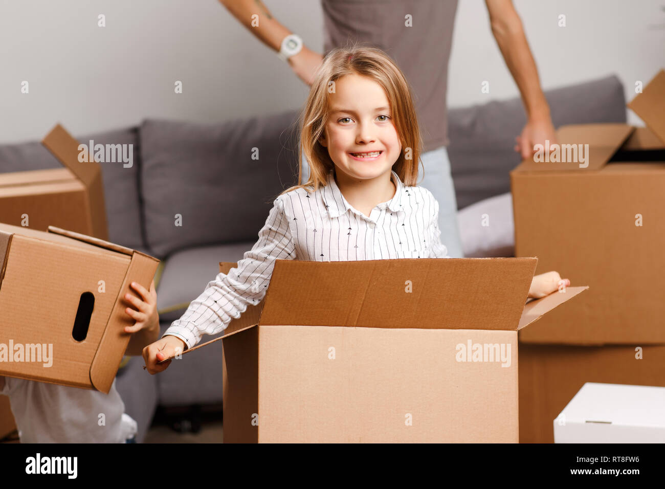 Girl sitting in cardboard box Stock Photo - Alamy