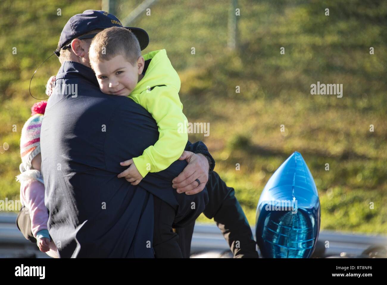 A child embraces his father, a Coast Guard Cutter Valiant crew member ...