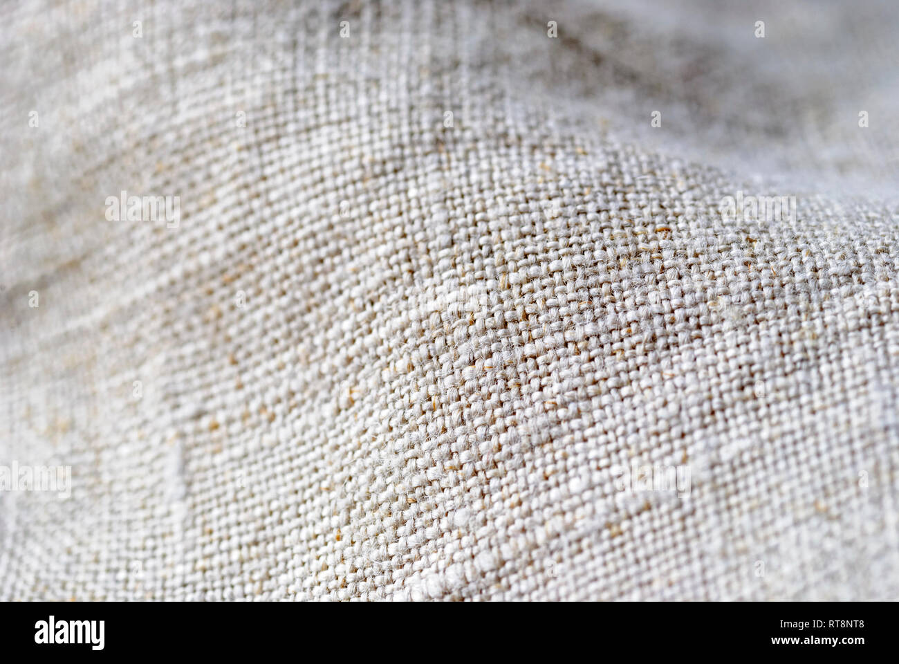 Texture if natural linen fabric draped in waves in a full frame ...
