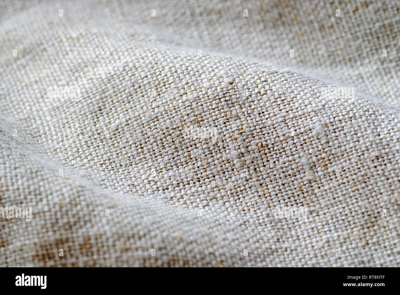 Texture if natural linen fabric draped in waves in a full frame ...