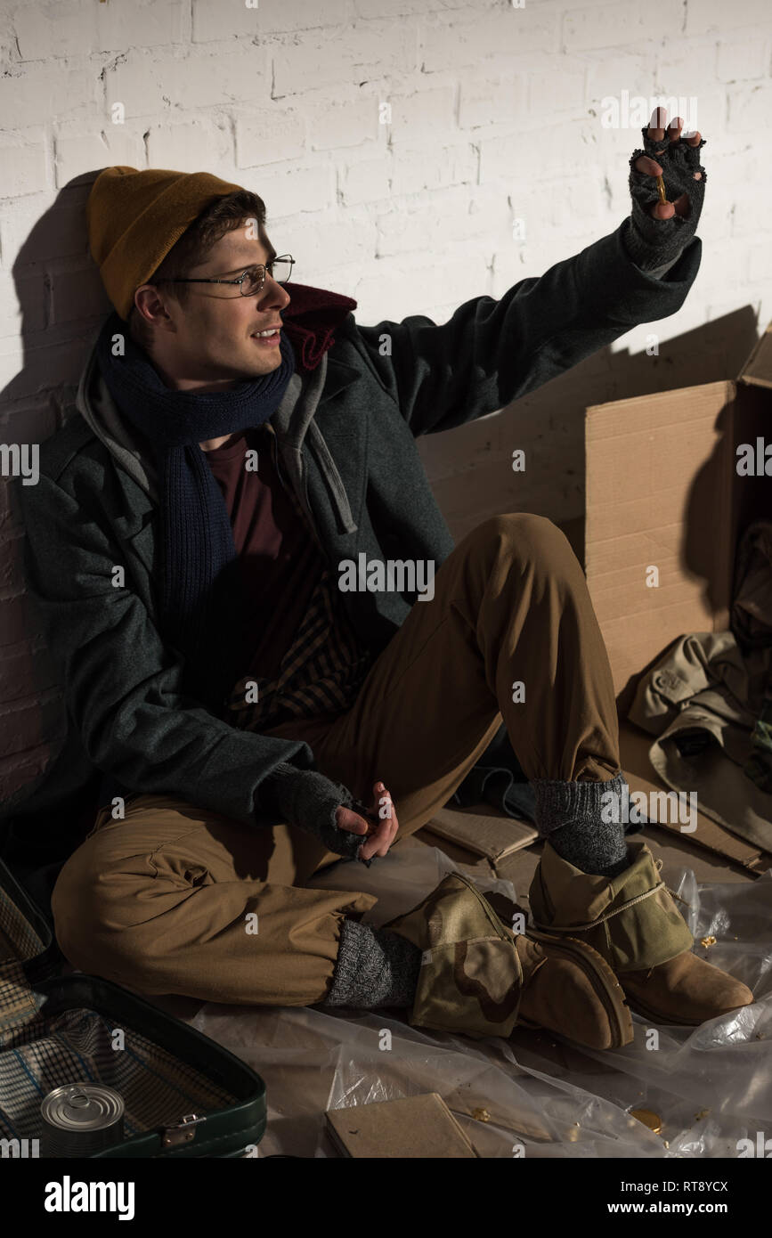 homeless beggar man sitting by brick wall and waving hand Stock Photo ...