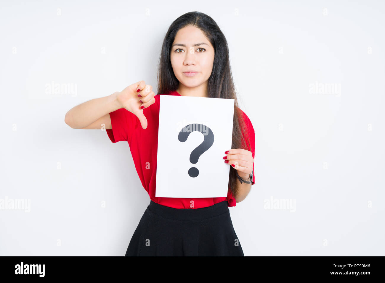Young brunette woman holding paper with question mark over isolated ...