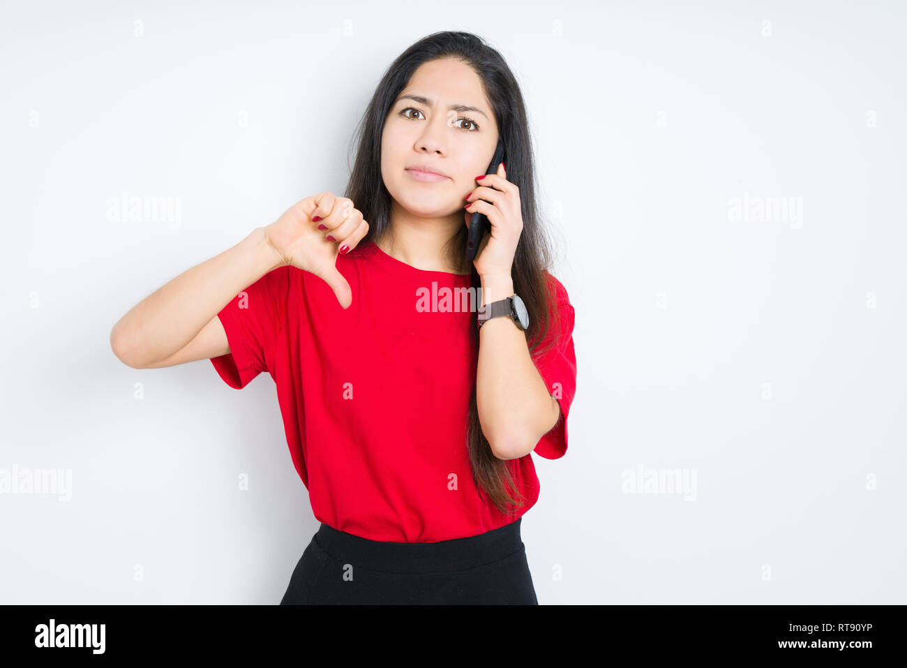 Young brunette woman talking on smartphone over isolated background ...
