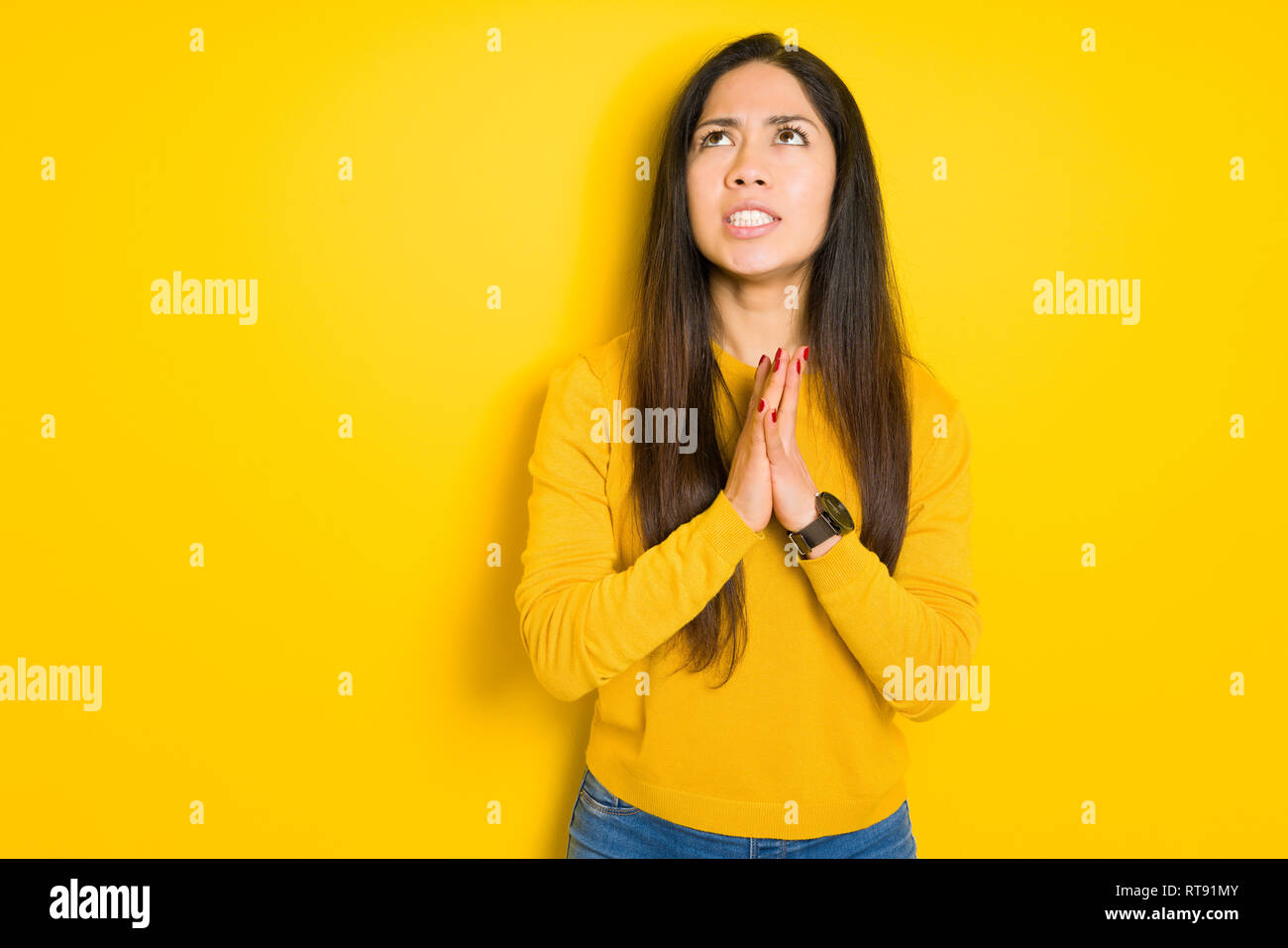 Beautiful brunette woman over yellow isolated background begging and ...