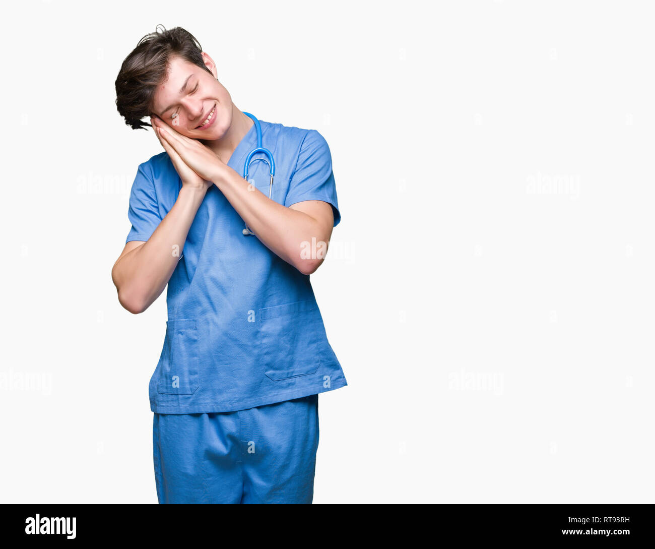 Young doctor wearing medical uniform over isolated background sleeping ...