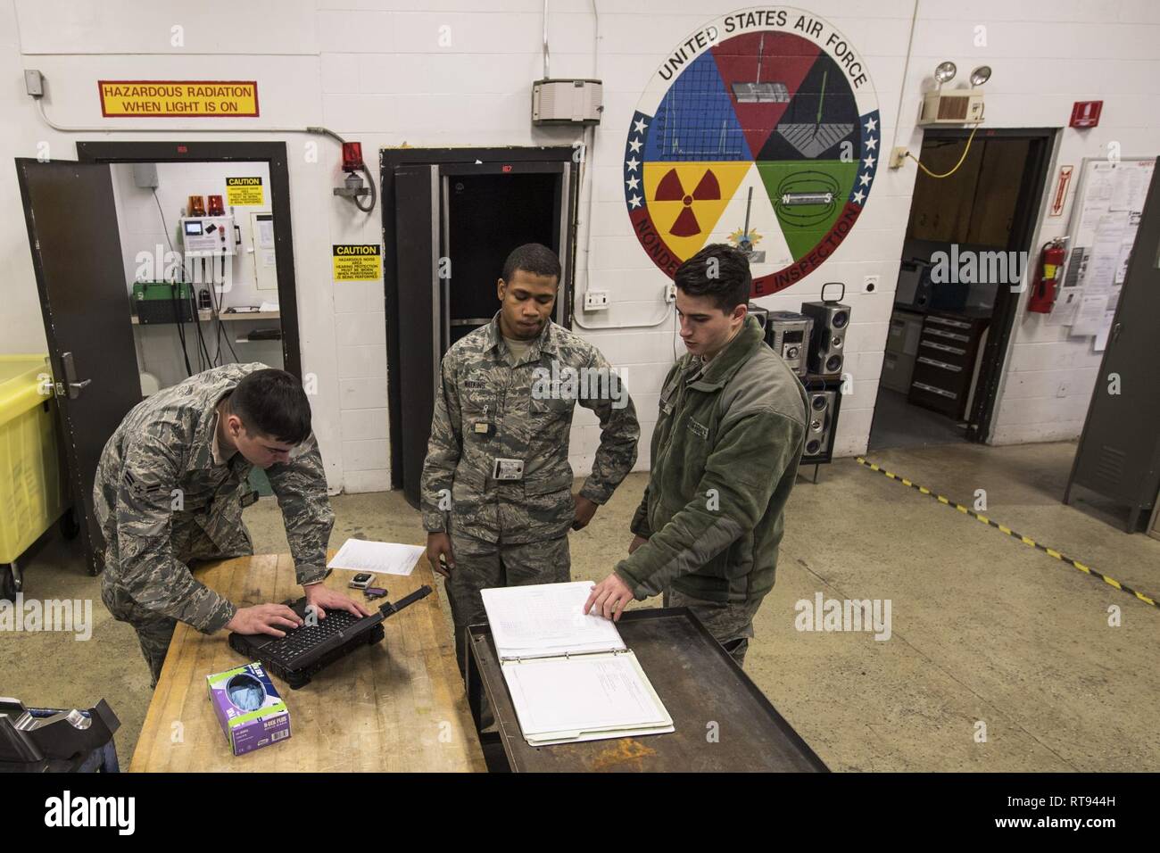 Airmen with the 5th Maintenance Squadron non-destructive inspection section review a maintenance ...