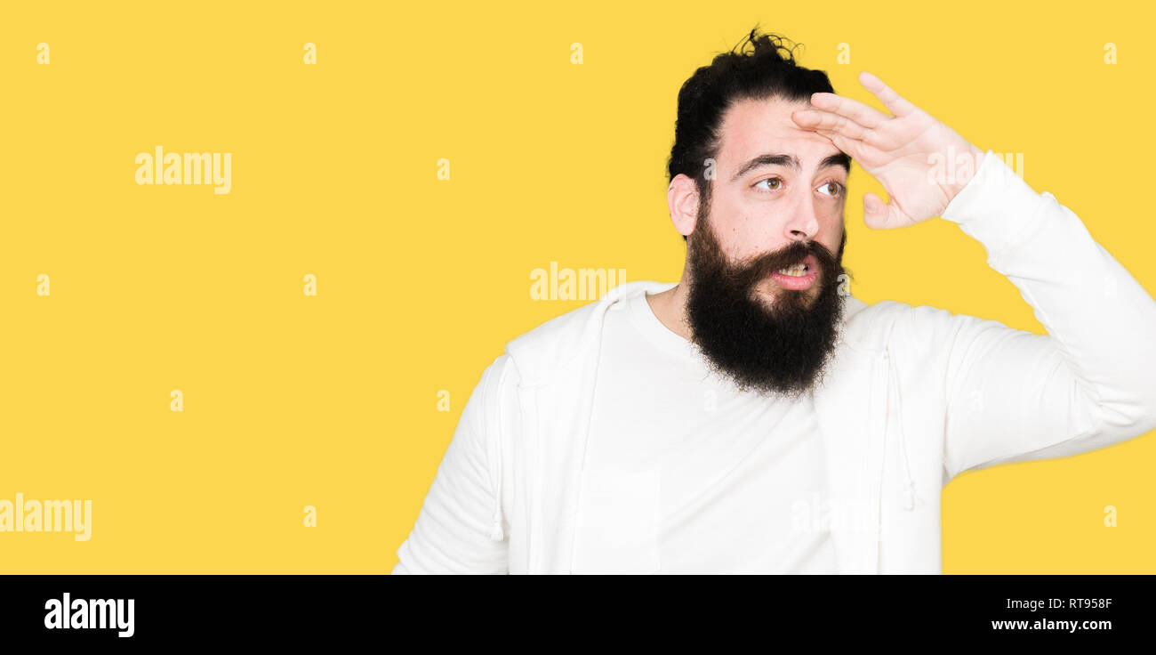 Young man with long hair and beard wearing sporty sweatshirt very happy ...
