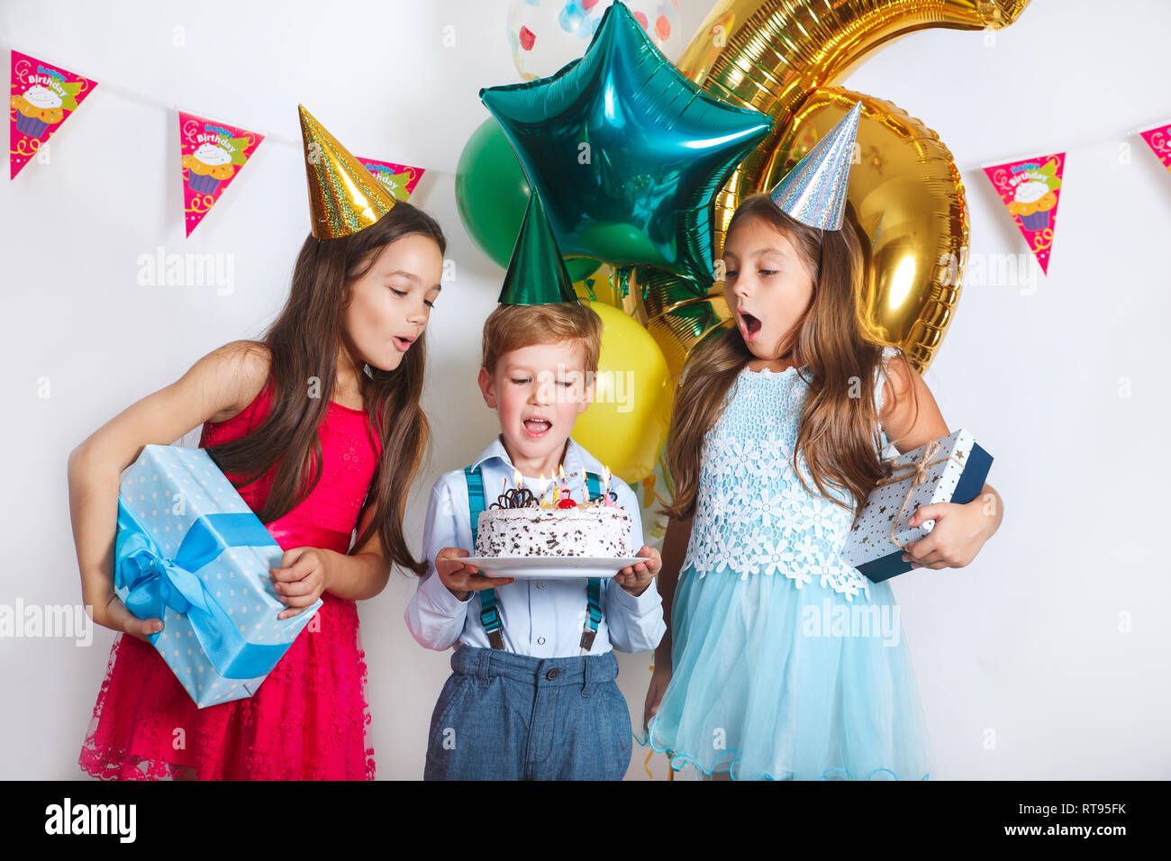 Children's birthday. Happy kids with cake and gifts Stock Photo - Alamy