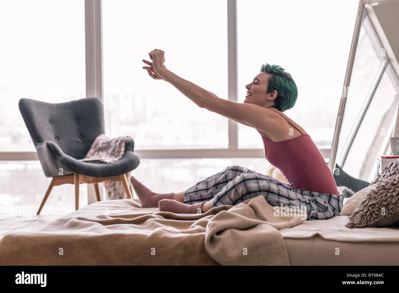 Happy woman stretching her body while waking up in the morning Stock ...