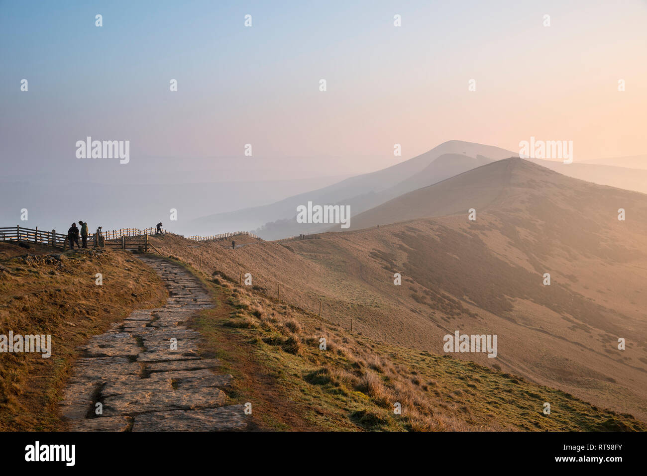 Beautiful landscape image of Mam Tor in Peak District on a Winter's morning with fog cloud ...