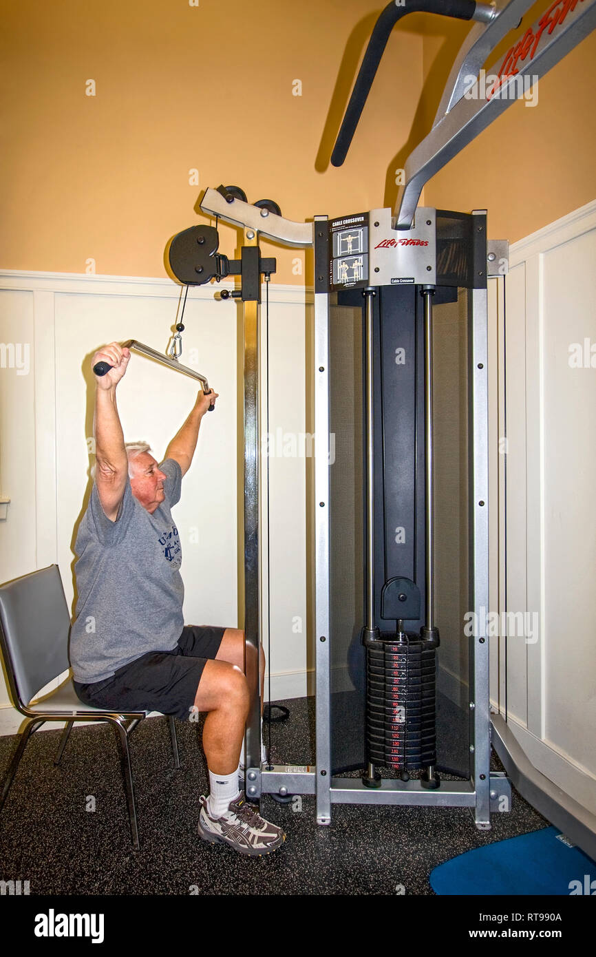 senior man exercising; overweight; cable crossover machine; health ...