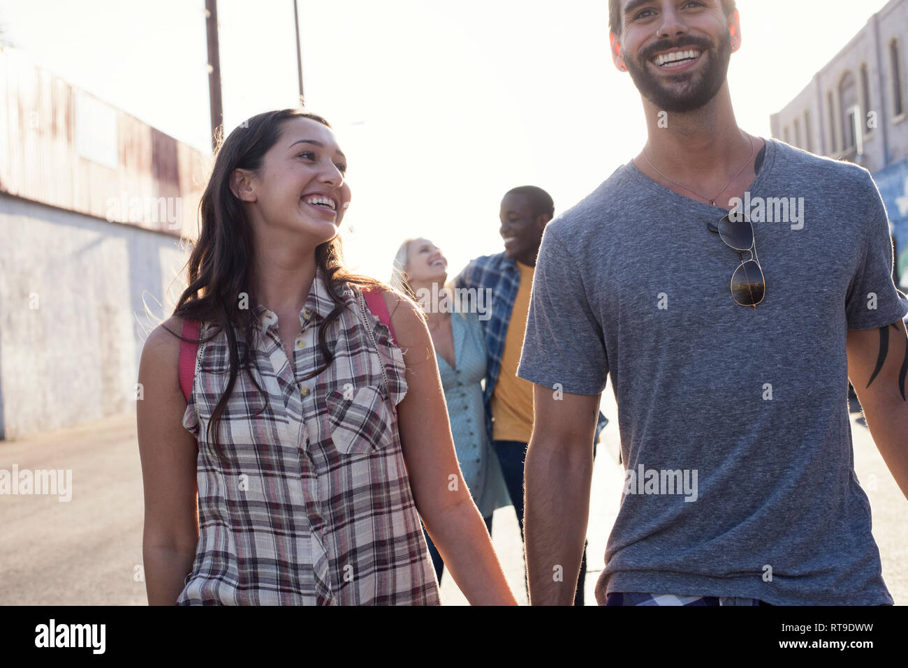 Two happy young couples outdoors on the go Stock Photo - Alamy