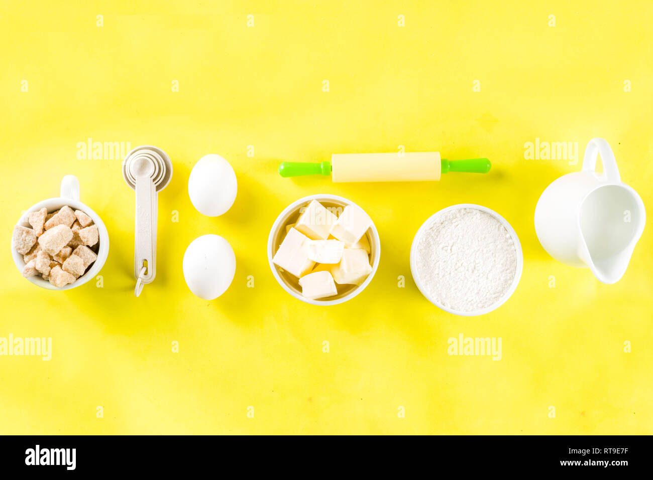 Baking ingredients and tools on trendy bright yellow background - flour ...
