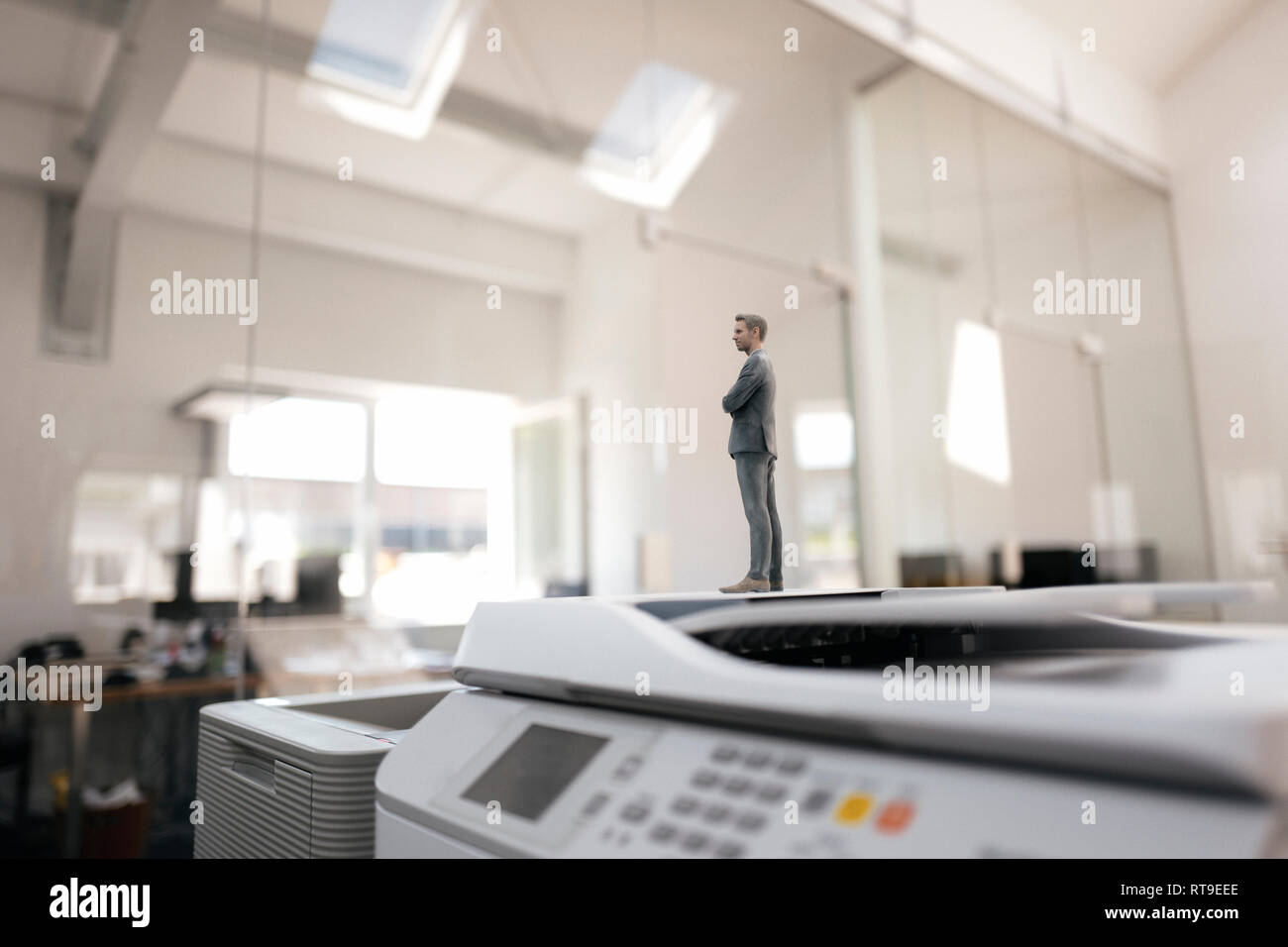 Businessman figurine standing on copy machines in modern office Stock ...