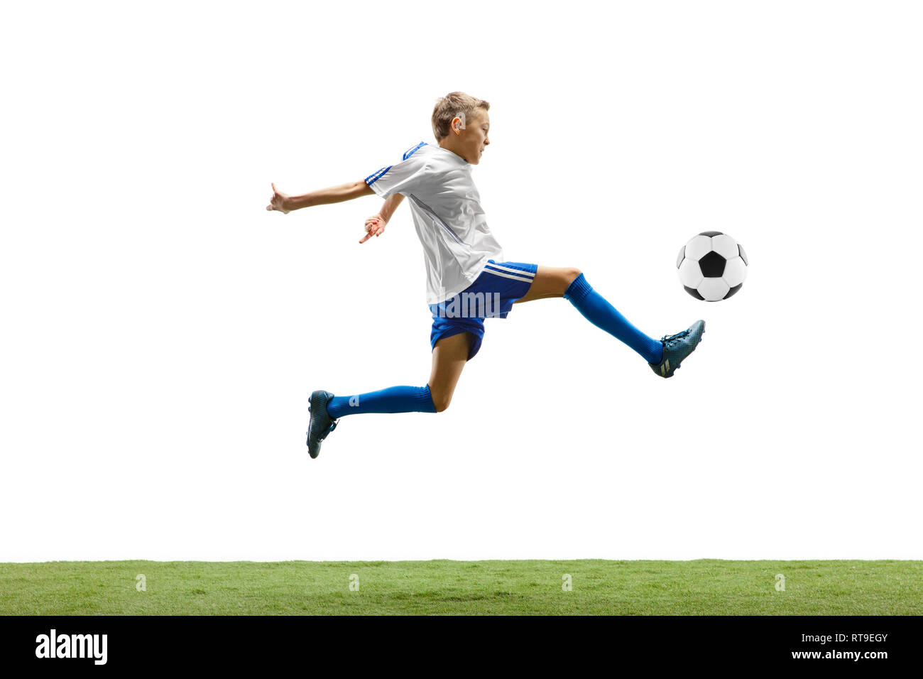 Young boy with soccer ball running and jumping isolated on white ...