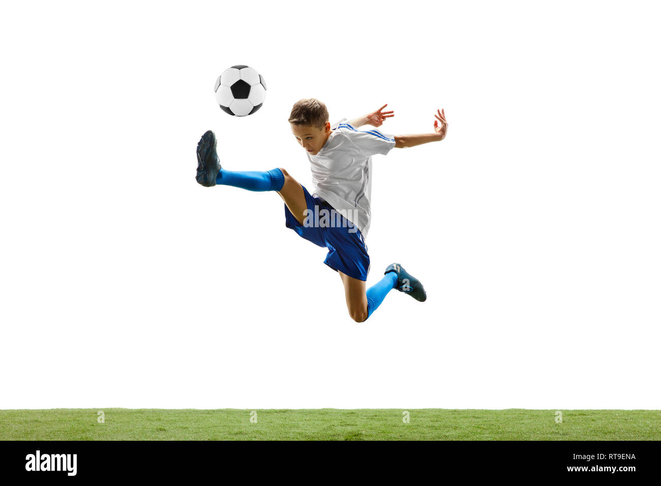 Young boy with soccer ball running and jumping isolated on white ...