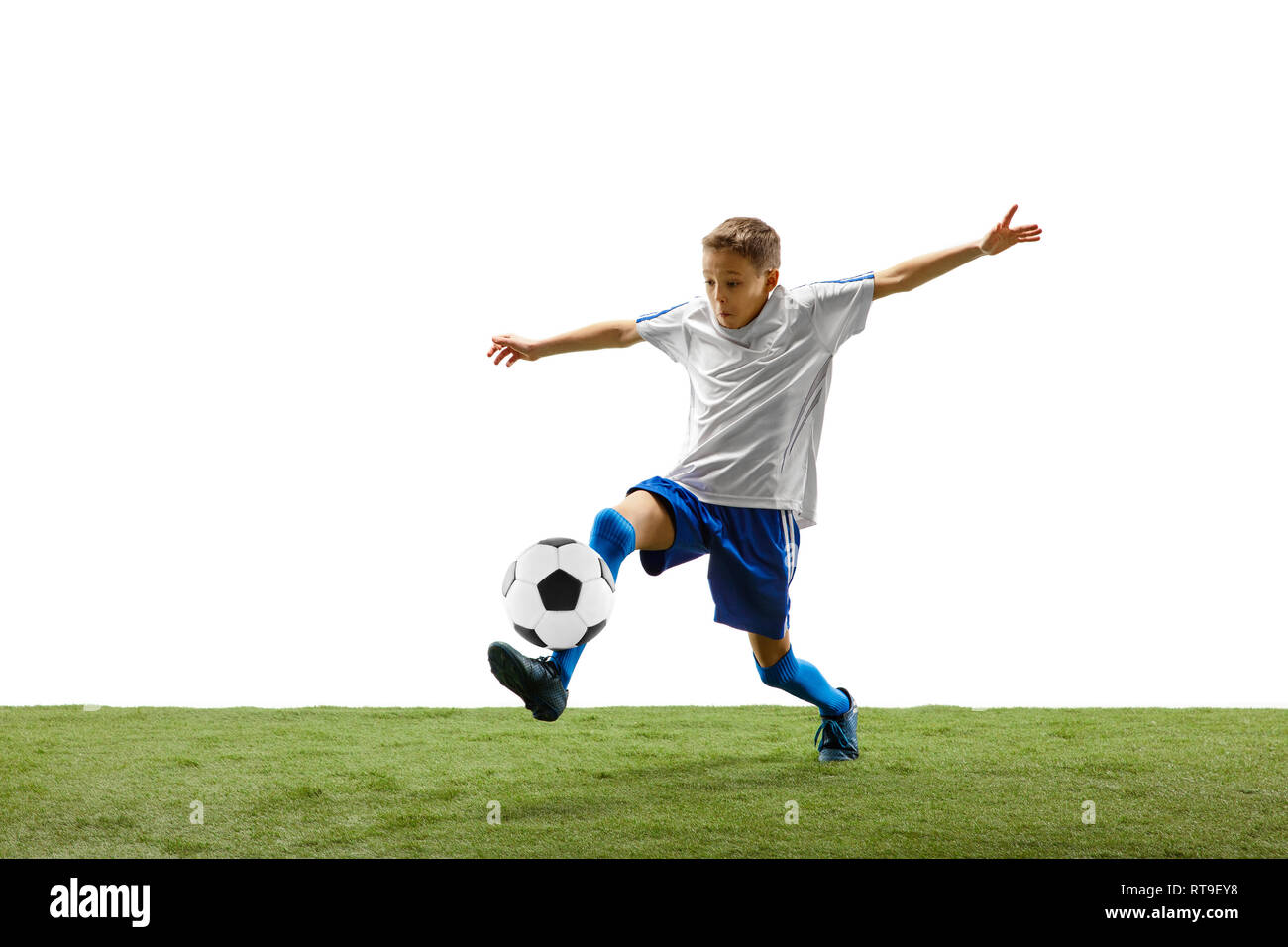 Young boy with soccer ball running and jumping isolated on white ...