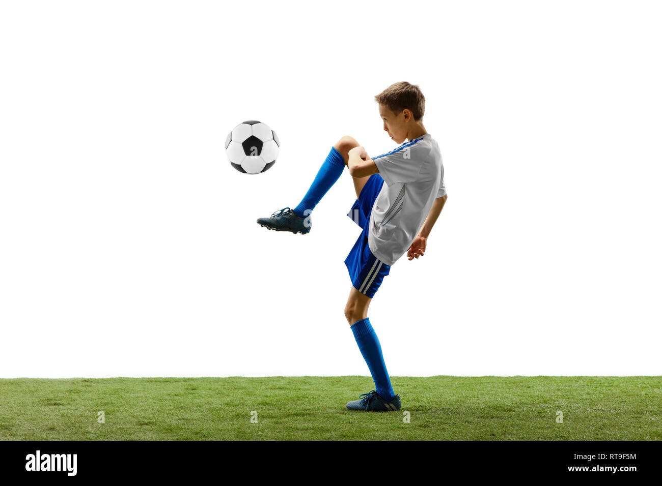 Young boy with soccer ball running and jumping isolated on white ...