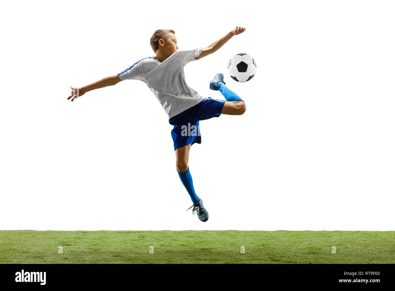 Young boy with soccer ball running and jumping isolated on white ...