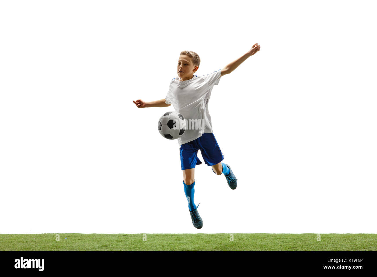 Young boy with soccer ball running and jumping isolated on white ...