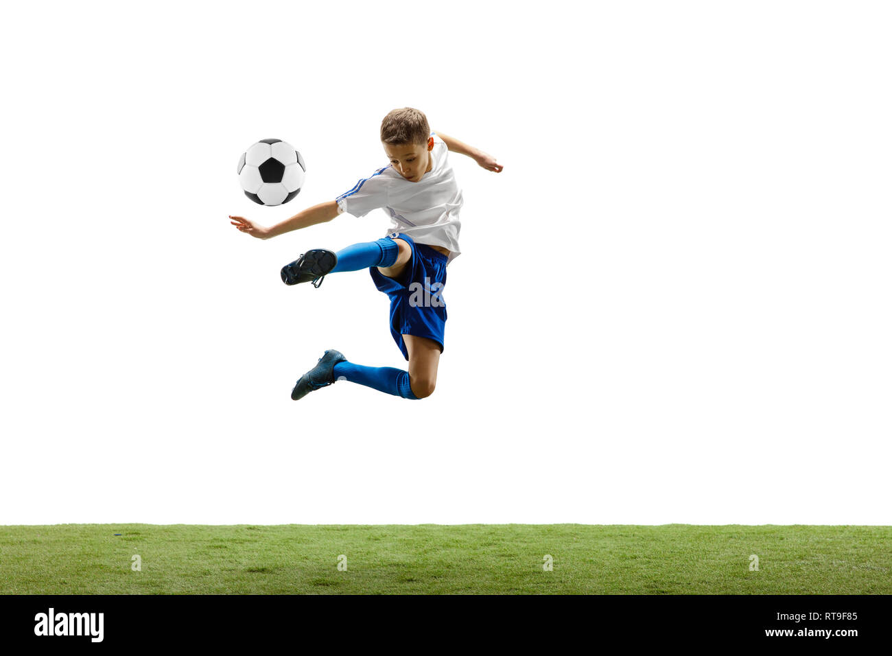 Young boy with soccer ball running and jumping isolated on white ...
