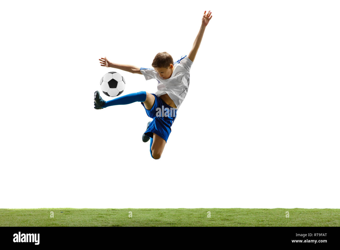 Young boy with soccer ball running and jumping isolated on white ...