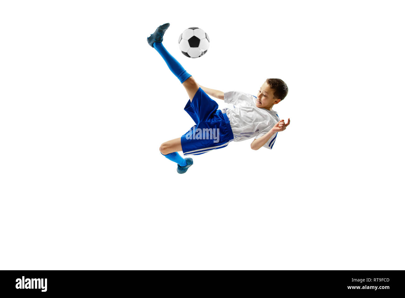 Young boy with soccer ball running and jumping isolated on white ...