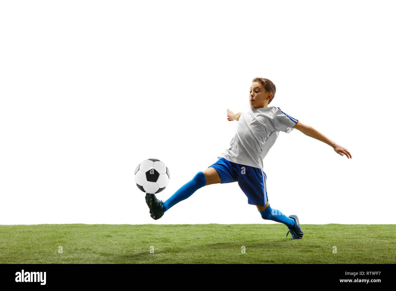 Young boy with soccer ball running and jumping isolated on white ...