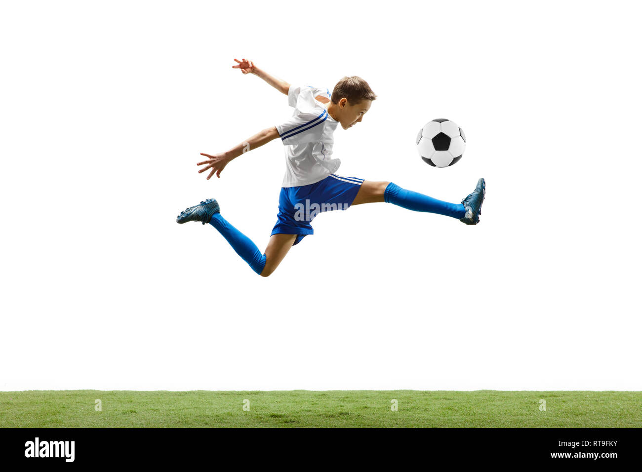 Young boy with soccer ball running and jumping isolated on white ...