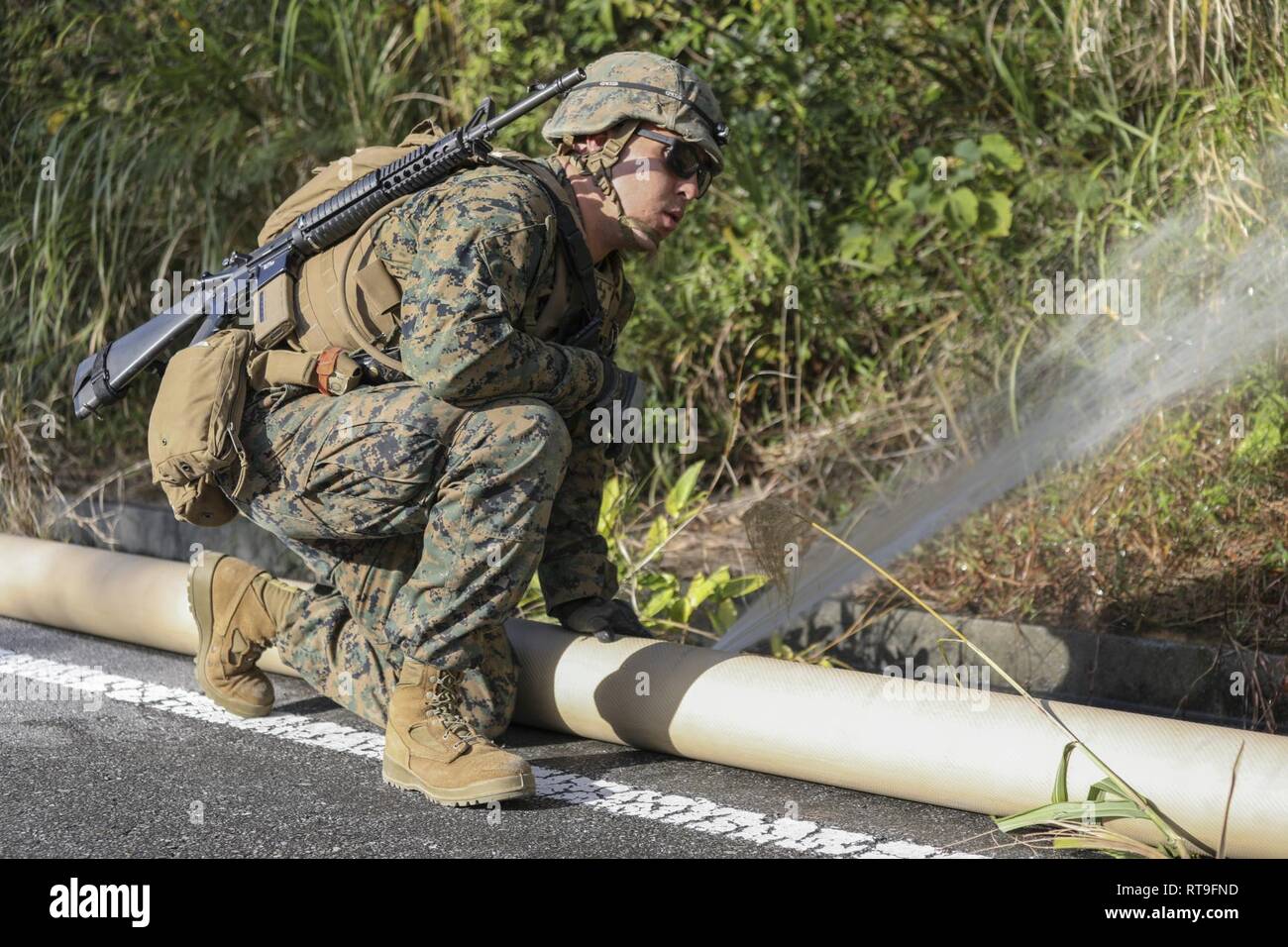 Lance Cpl. Daniel D. Cruz examines a hole in a fuel hose on Jan. 28 ...