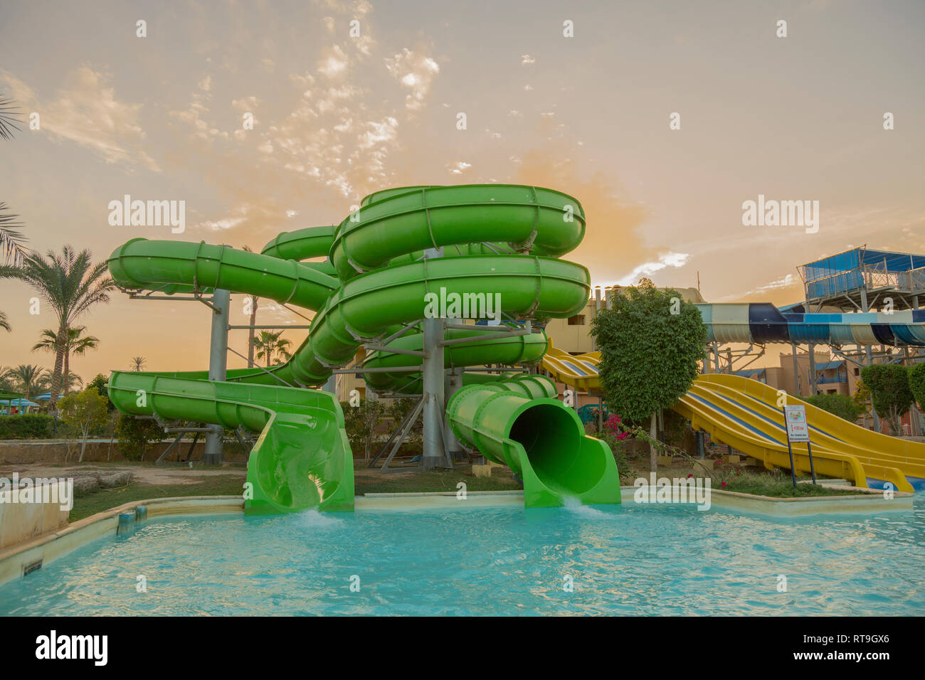 Colourful plastic slides in aquapark in the sunset. sliders, water park ...