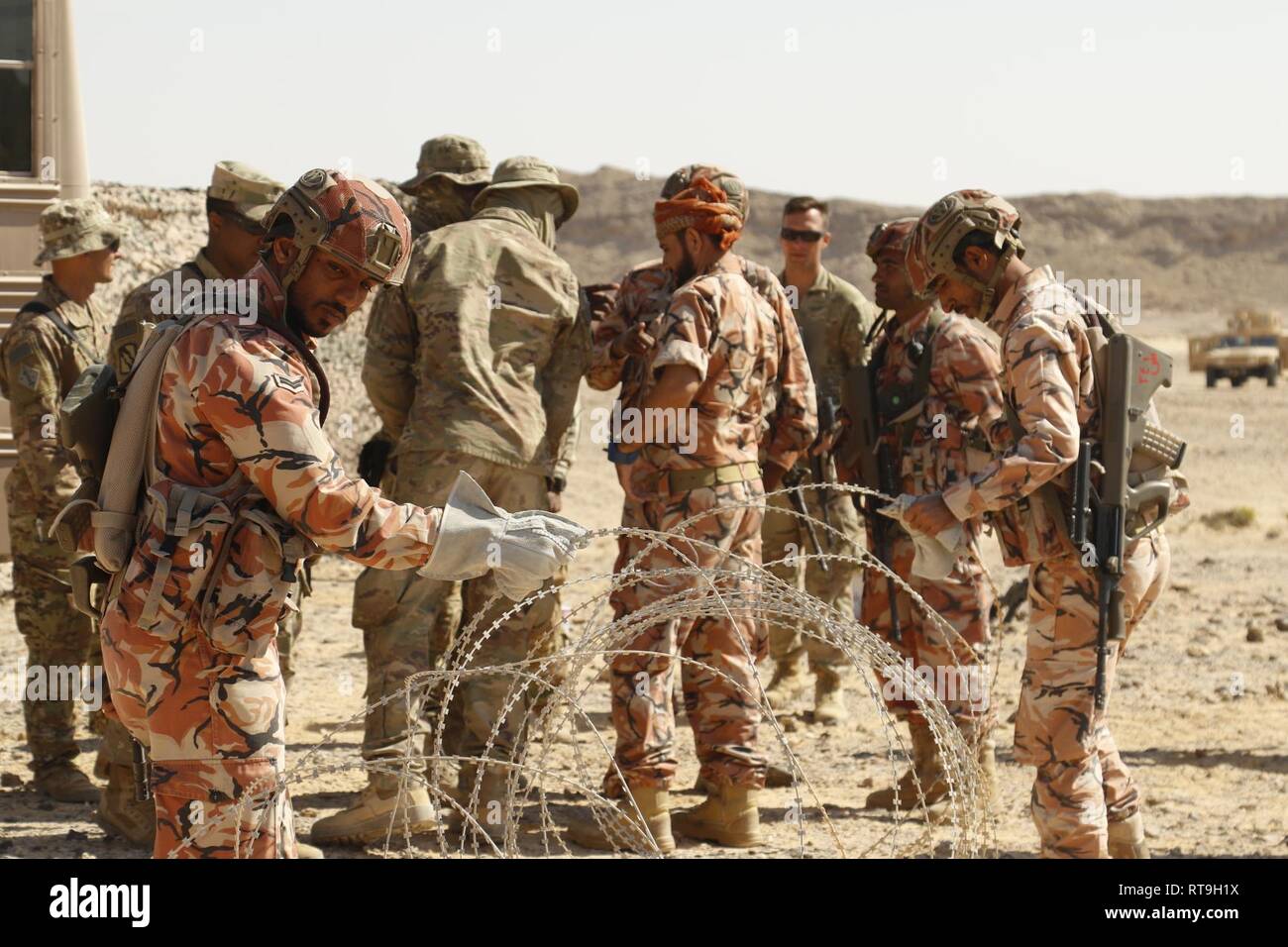 Soldiers from the Royal Army of Oman reset concertina wire for a mock ...