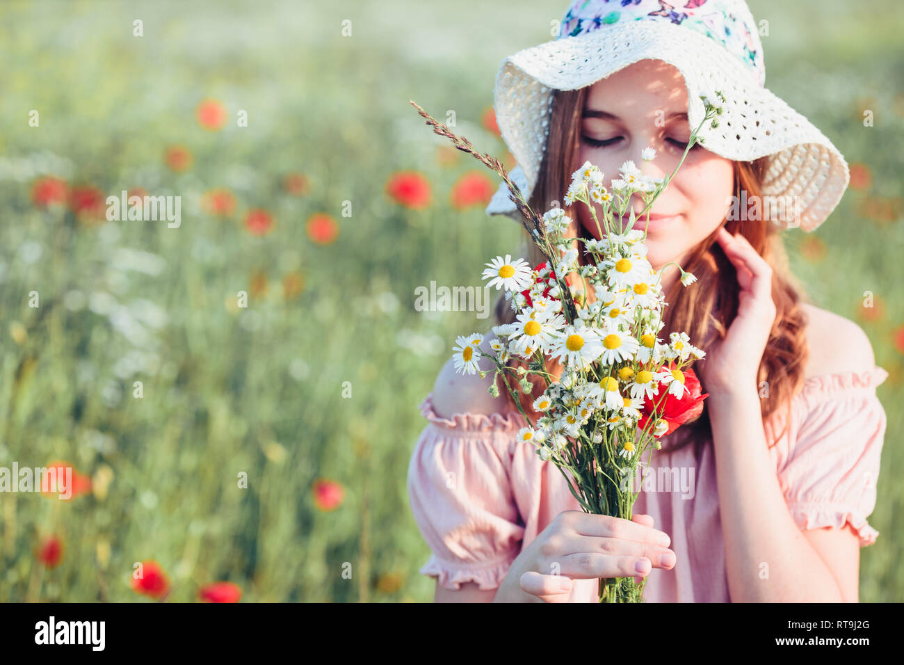 Beautieful young girl in the field of wild flowers. Teenage girl ...