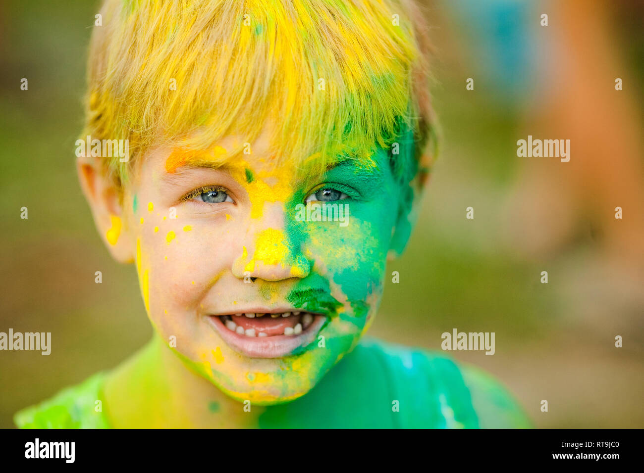 Portrait of happy boy with blue eyes with strabismus smeared with ...