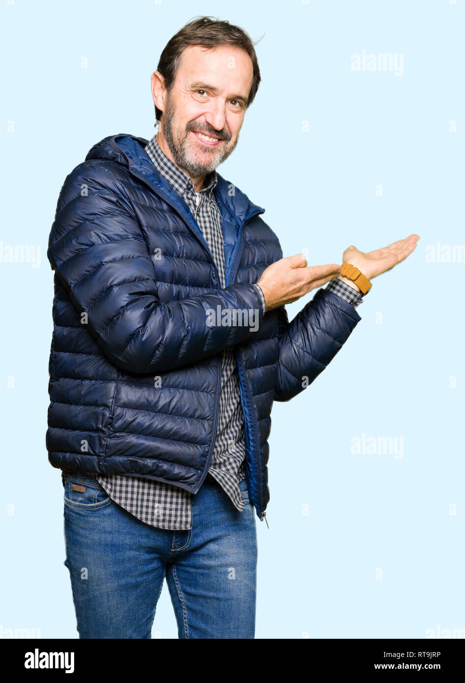 Middle age handsome man wearing winter coat Inviting to enter smiling ...