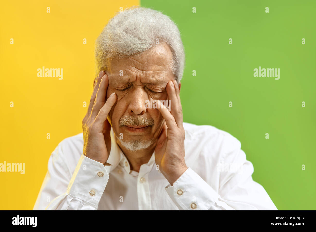 Portrait of upset old man covering face while crying. Isolated on color ...