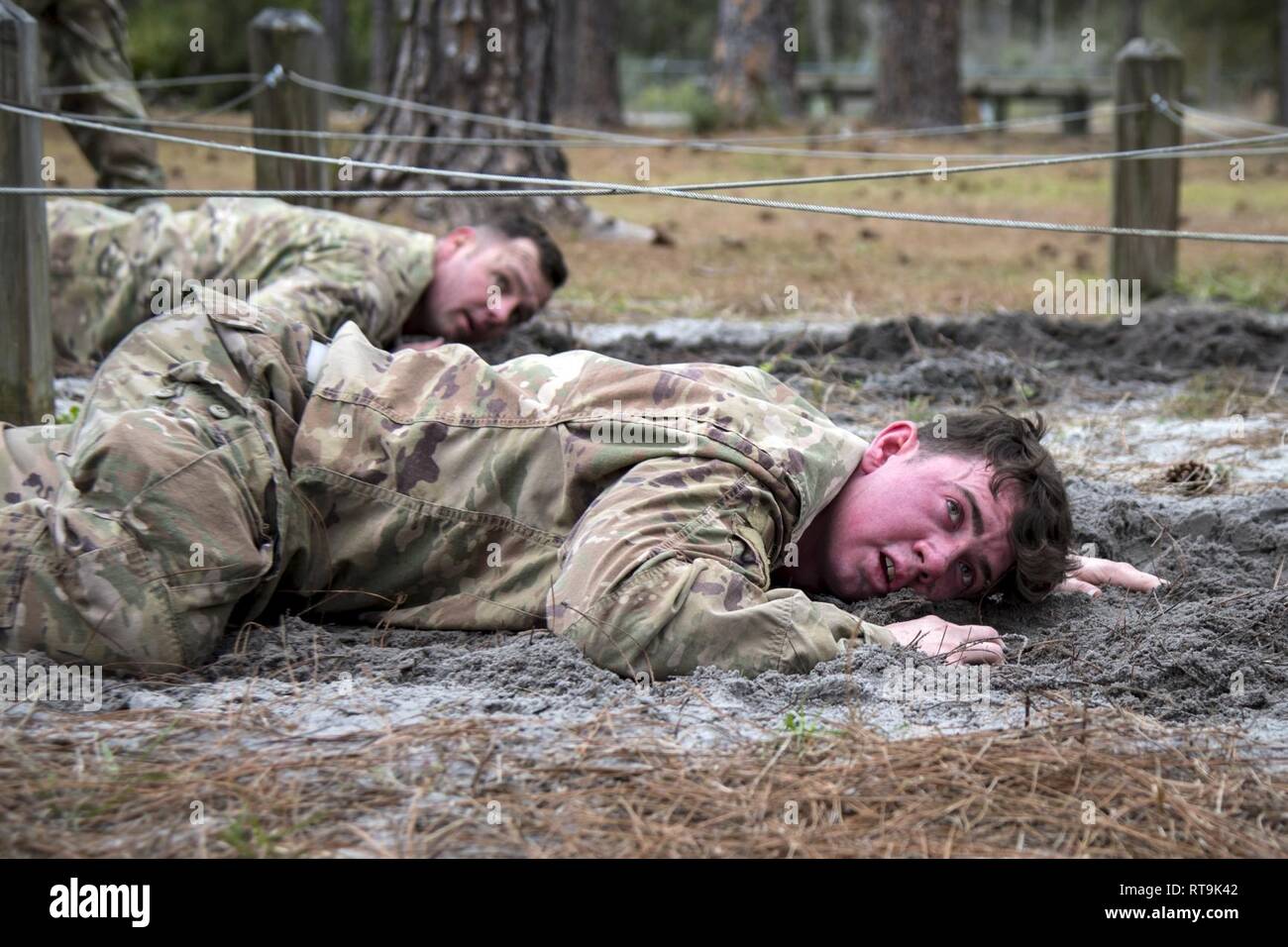 Airmen low crawl through an obstacle during an Army Air Assault ...