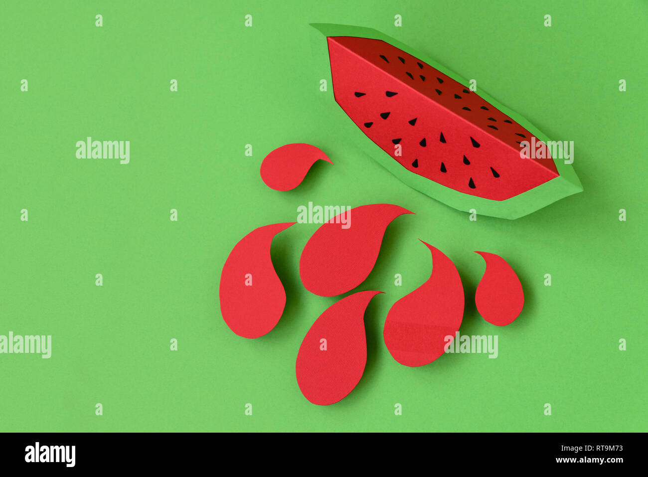 Paper watermelon slice with splashes on green pastel background ...