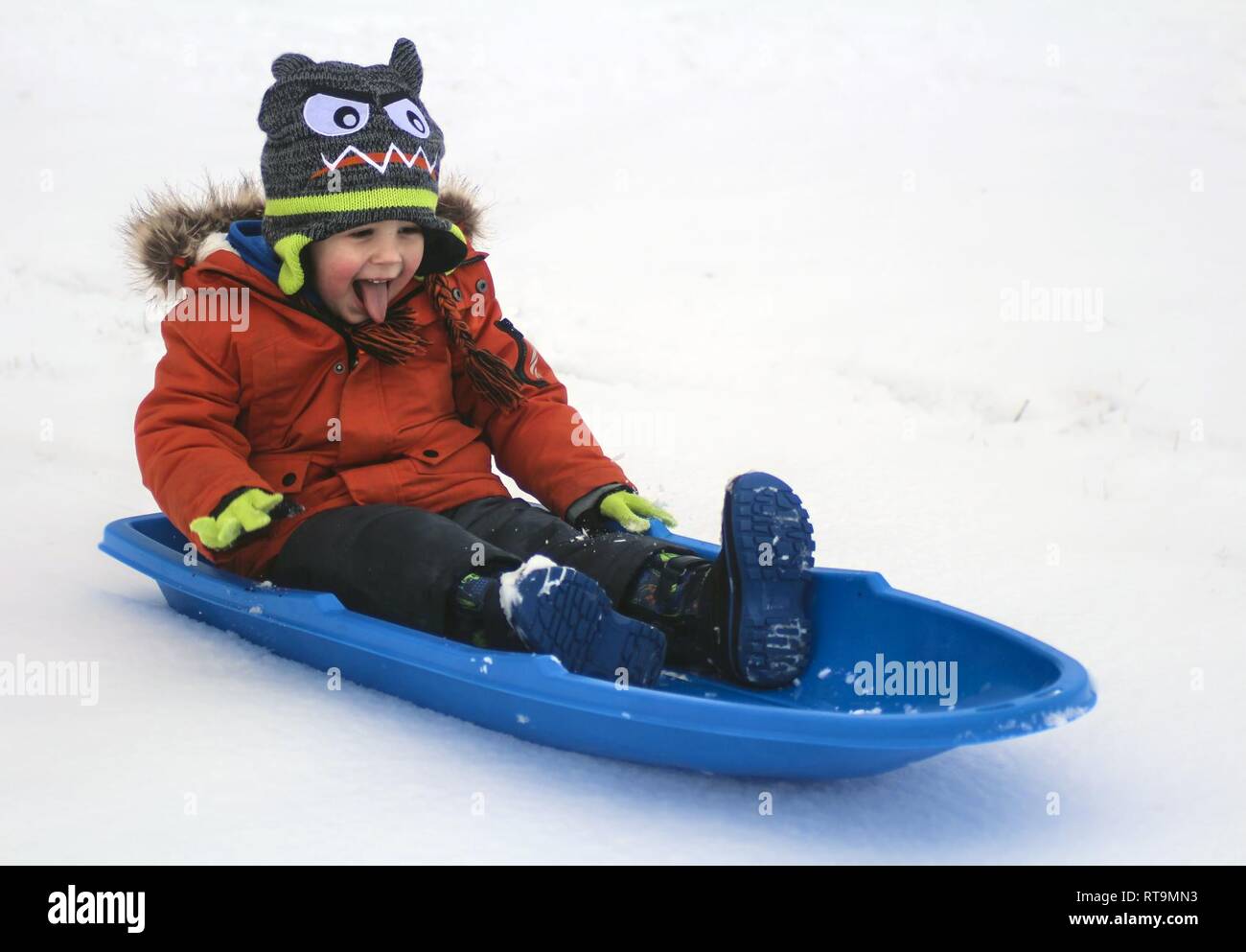 Members of the Kenerley family go sledding down a hill while enjoying ...