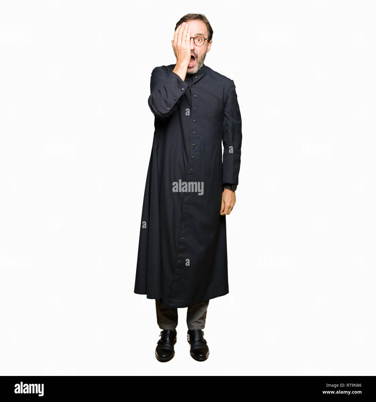 Middle age priest man wearing catholic robe Yawning tired covering half ...