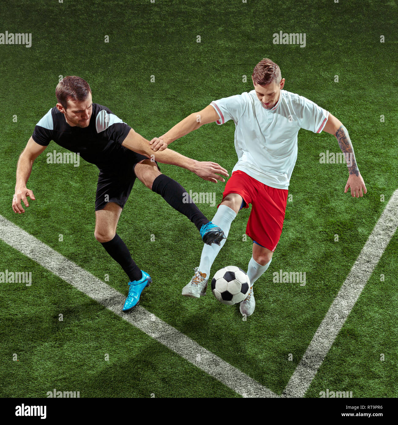 Football player tackling for ball over green grass background ...