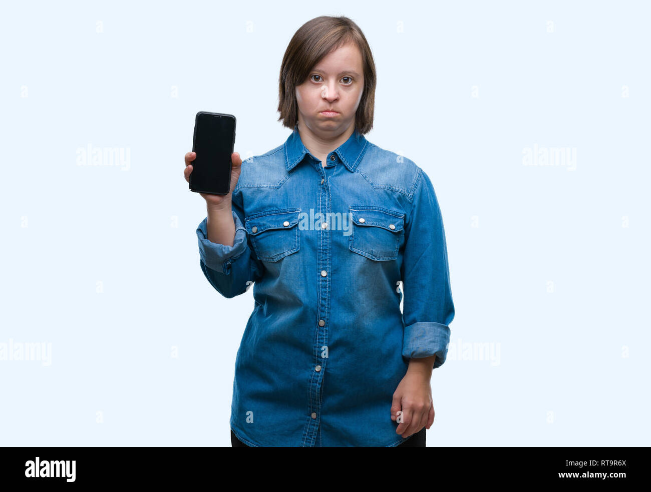 Young adult woman with down syndrome showing smartphone screen over ...
