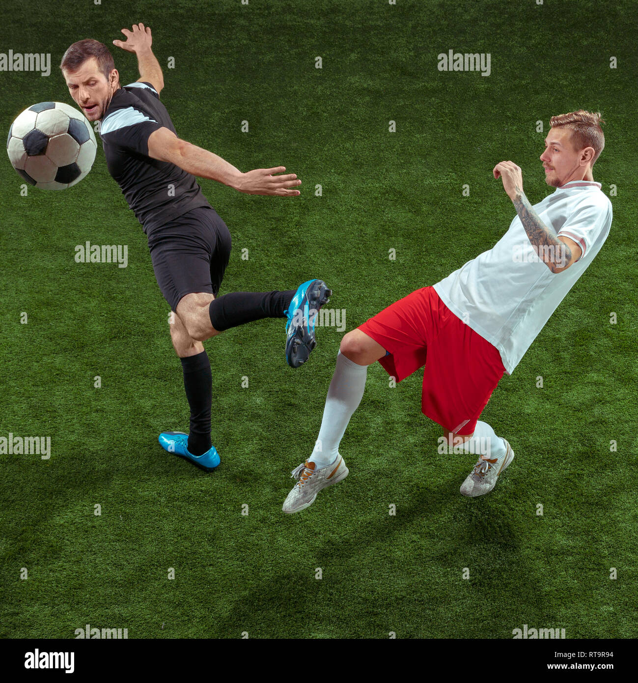 Football player tackling for ball over green grass background ...