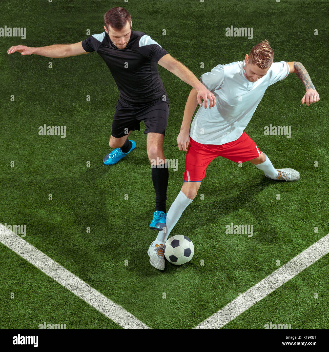 Football player tackling for ball over green grass background ...