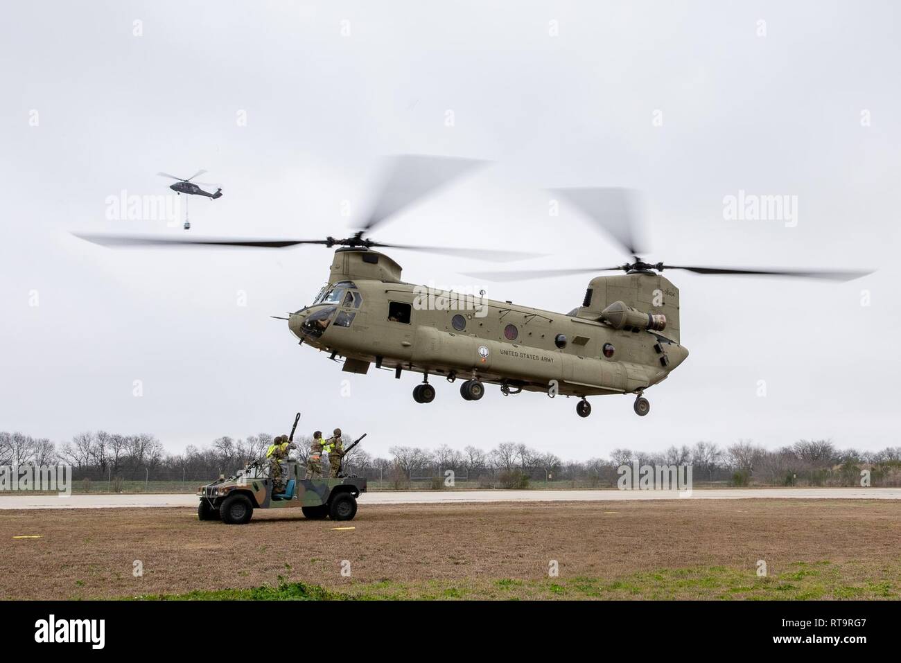 A CH-47 Chinook helicopter prepares to receive a Humvee during a sling ...